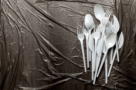 플라스틱 칼 포크 숟가락과 칼 플라스틱 및 미세 플라스틱으로 환경오염 검은 색 플라스틱 배경입니다 텍스트의 공간을 복사합니다 0