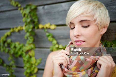 Wanita Pirang Platinum Berambut Pendek Yang Cantik Berdiri Dengan Latar