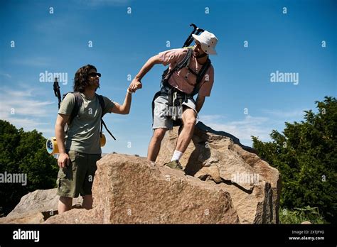 Two Young Gay Men Hike Together In Nature On A Sunny Summer Day Stock