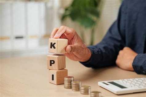 A Close Up Of A Businessman Hand Holding Wooden Cube Blocks Spelling