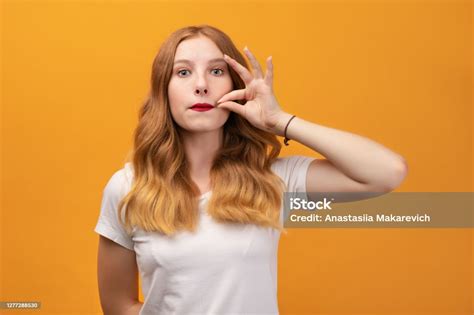 청녀는 비밀을 지키고 뺨 근처에 손가락을 들고 있다고 약속합니다 침묵과 비밀 개념 금지됨에 대한 스톡 사진 및 기타 이미지