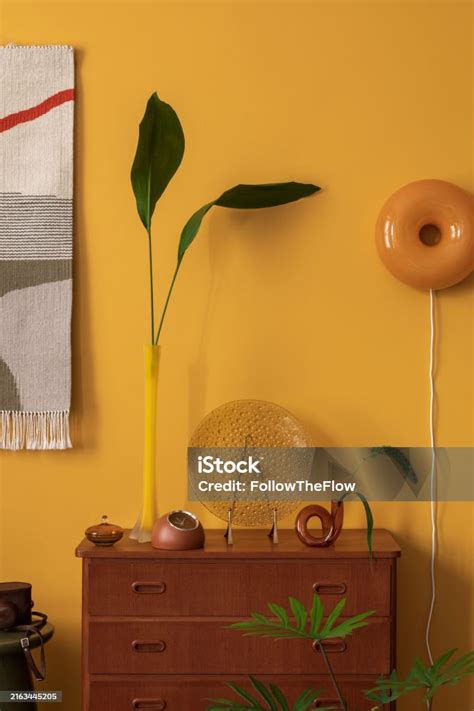 킬림 러그 나무 찬장 나뭇잎이 있는 노란색 꽃병 시계 식물 원형 램프 및 개인 액세서리가 있는 빈티지 거실 인테리어의 미니멀한 구성 가정 장식 템플렛 0명에 대한 스톡 사진