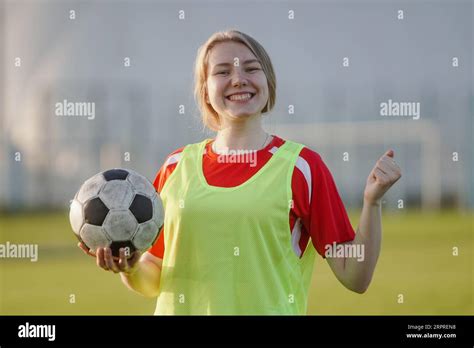 Happy Female Football Player In Sportwear Celebrating Victory Holding