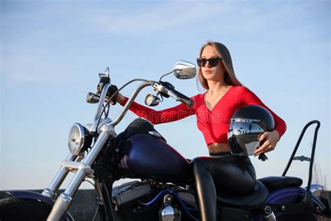 Beautiful Young Woman With Helmet Sitting On Motorcycle Outdoors Stock