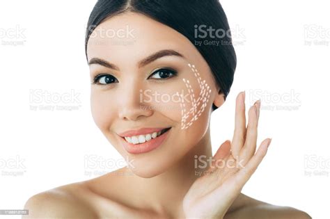 얼굴에 화살표 리프팅 피부의 개념과 얼굴의 완벽한 피부를 가진 아시아 여성의 초상화 미용 탄력과 얼굴의 젊은 피부 가꿔주기에