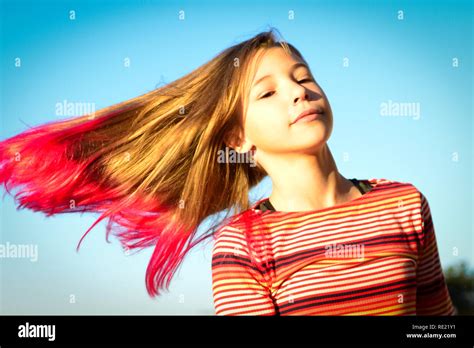 Tween Girl Is Isolated Against The Sky While Twirling And Swinging Her