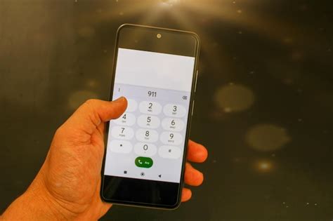 Una persona que sostiene un teléfono con el número 911 en la pantalla