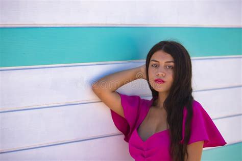 Young Beautiful Brunette Woman With Long Hair Wearing A Pink Suit