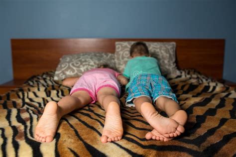 Brother And Sister Relaxing Feet Of Chldren On A Bed Stock Image