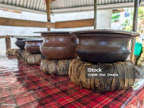 소박한 탄자니아 부엌 환경에서 빨강과 검은 체크 무늬 식탁보 위에 놓인 밀짚 고리에 금속 뚜껑이 달린 전통적인 항아리 0명에 대한 스톡 사진 및 기타 이미지 Istock