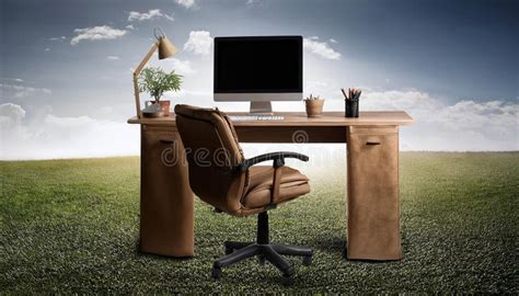 An Innovative Office Desk Setup On A Grassy Field With A Computer Chair And Lamp Under A Clear