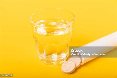 발포성 정제와 노란색 배경에 물 한 잔 비타민 건강 개념입니다 면역 약물 복사를 위한 공간입니다 텍스트를 위한 공간입니다 제품
