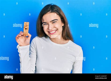 Young Caucasian Girl Eating Protein Bar As Healthy Energy Snack Looking