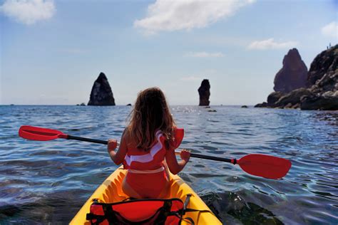 빨간 수영복을 입은 젊은 갈색 머리 여성 아이슬란드처럼 화산 바위 주변에서 카약에서 수영 다시 보기입니다 크리스마스 휴가 및 여행 개념 건강한 생활방식에 대한 스톡 사진 및