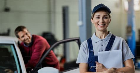 작업장에 서서 카메라를 바라보는 행복한 여성 자동차 정비사의 초상화 배경에 고객이 있습니다 사진 Unsplash의 세르비아 이미지