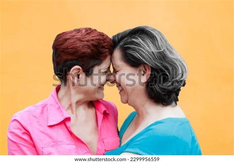 シニアのゲイのレズビアンのカップルは外で優しい瞬間を楽しみます Lgbtqの成熟した女性の恋人は屋外で笑っています写真素材
