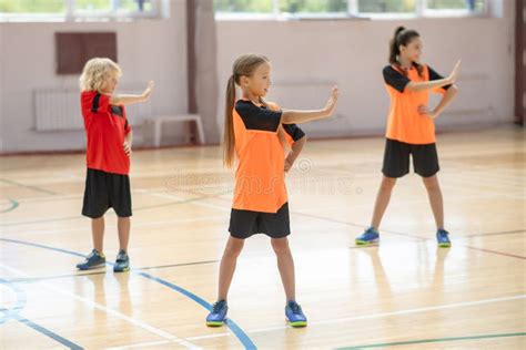 Tres Niños Haciendo Ejercicio En El Gimnasio Y Girando A La Izquierda