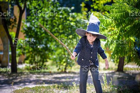 야외에서 마술 지팡이를 가지고 노는 뾰족한 모자를 쓴 유아 소년 작은 마법사 할로윈 컨셉 6 7 살에 대한 스톡 사진 및 기타 이미지 Istock