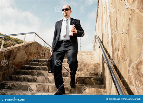 Confident Middle Age Businessman With Briefcase Walking Upstairs Close