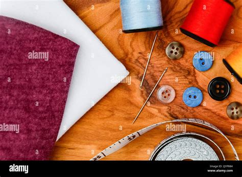 Sewing Accessories And Fabric On A Wood Background Threads Needles