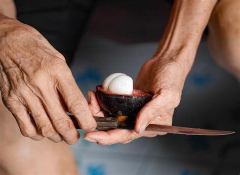 Premium Photo Cropped Hands Of Man Cutting Fruit