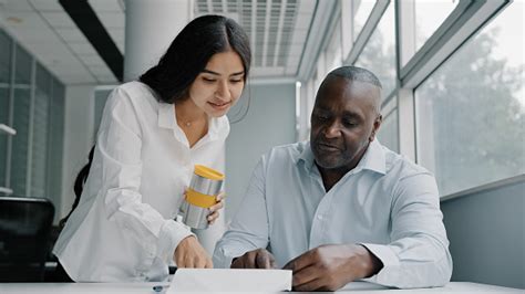 두 명의 동료 비즈니스 파트너 사무실 동료가 서류 작업 확인 정보를 분석합니다 아라비아 여자 수표 문서 서류 보고서 도움말 아프리카 나이든 남자 마케팅 데이터 기업 문서 2