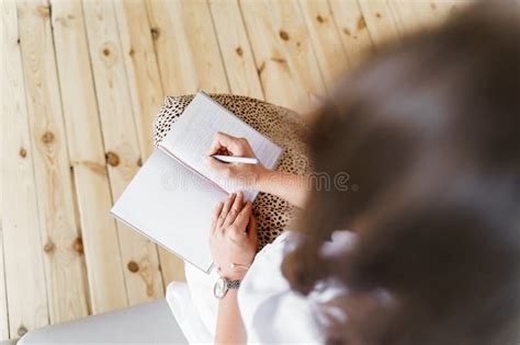 A Woman Is Sitting And Writing In A Notebook Stock Image Image Of Computer Beauty 279715397