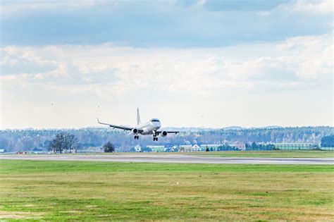흐린 하늘을 배경으로 그단스크 레흐 바웬사 공항의 활주로에 착륙하는 하얀 비행기의 다이나믹한 샷 0명에 대한 스톡 사진 및 기타 이미지 Istock