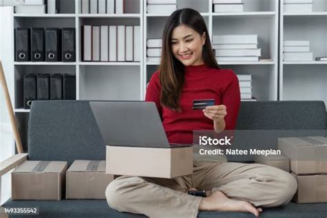 노트북과 은행 신용카드를 들고 웃는 여자 집에서 온라인 모바일 쇼핑에 참여 인터넷 상점에서 상품이나 서비스를 구매하는 행복한