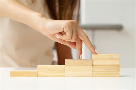 Premium Photo Hand Arranging Wood Cube Stacking As Step Stair