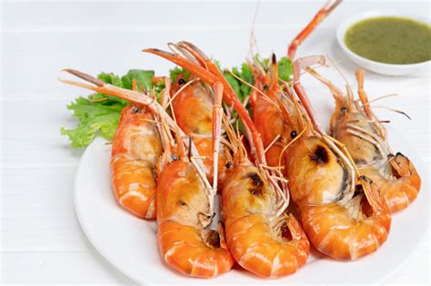구운 새우 또는 구운 새우와 해산물 소스 흰색 나무 배경에 흰 접시에 매우 맛 있습니다 새우류에 대한 스톡 사진 및 기타 이미지