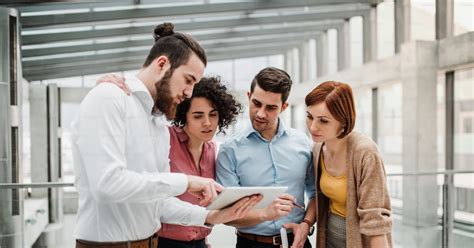 태블릿과 집의 모델을 가진 젊은 건축가 그룹이 사무실에 서서 일하고 이야기합니다 사진 Unsplash의 사무실 이미지