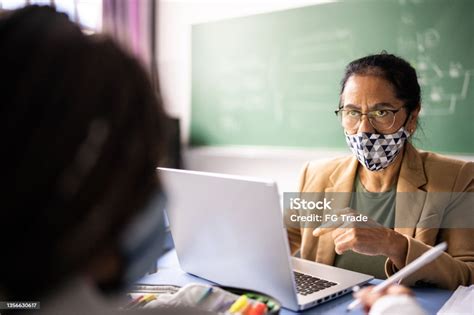 교실에서 학생과 이야기하는 선임 교사 얼굴 마스크를 사용하여 보호 마스크에 대한 스톡 사진 및 기타 이미지 보호 마스크