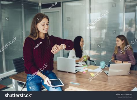 2 Checking Time On Wristwatch While Working On Laptop In Modern