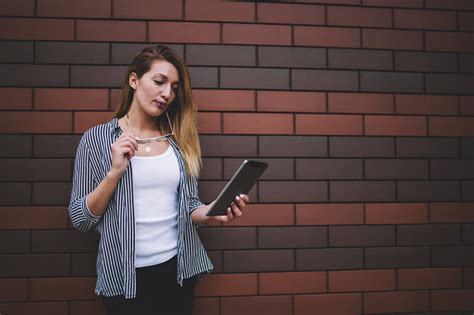 복사 공간 근처에 서있는 동안 디지털 태블릿에 소득 메시지를 읽고 펜션 힙스터 소녀 휴대용 Pc야외를 통해 4g 인터넷 및 네트워킹을 사용하기위한 잔액을 확인하는 집중 여성