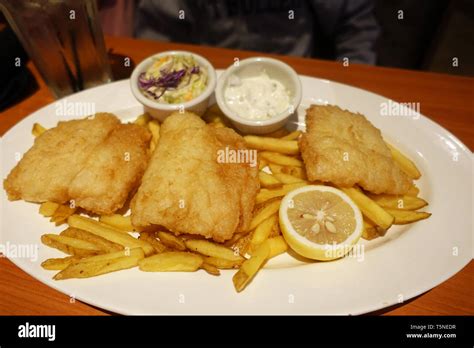 Fish And Chips With Tartare Sauce Coleslaw And Lemon On White Plate