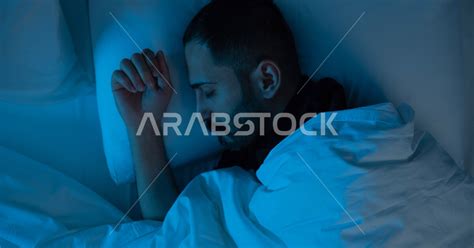 صوره مقربه لرجل عربي خليجي سعودي مستلقي على فراشه، النوم الباكر النوم