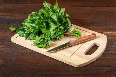 A Bunch Of Green Parsley On A Wooden Table With A Knife Stock Image