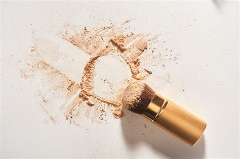 부드러운 화장품 브러시 강모에 반짝이는 파우더 파우더는 아름다움과 메이크업의 개념으로 복사 할 공간이있는 밝은 배경에 테이블 위에 흩어져 있습니다 고품질 사진 메이크업