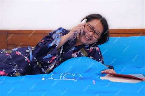 Premium Photo A Woman In A Kimono Lying On Her Side Talking On A Cell