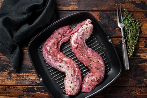 허브와 올리브 오일그릴 팬에 요리 할 준비가 원시 부드러운 돼지 고기 필레 요리하지 않은 고기 나무 배경 위쪽 보기 0명에 대한