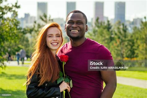 봄 가을 공원에서 흰 장미를 들고있는 인종 간 커플의 클로즈업 25 29세에 대한 스톡 사진 및 기타 이미지 25 29세