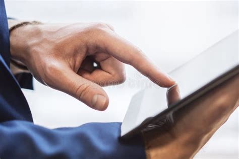 Man S Finger Navigating The Screen Of An Advanced Tablet On A Desk Set