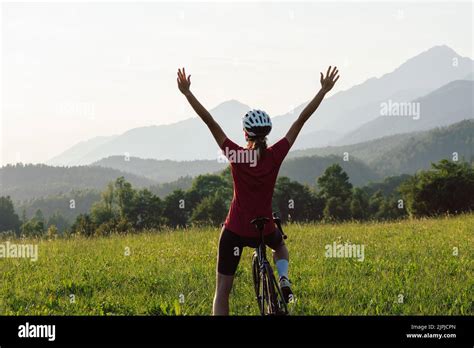 Happy Female Road Racing Cyclist In Joy With Arms Raised Above Her