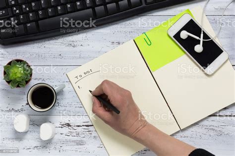 흰색 나무 책상의 최고 볼 수 있습니다 손 컵 커피 마쉬 멜 로우 녹색 선인장 흰색 이어폰 스마트폰 주위 검은 컴퓨터 키보드의