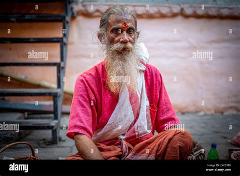 An Indian Godman In A Traditional Costume Sitting On A Sidewalk On The