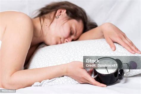 잠자는 여 자가 알람 벨에서 일어나 하지 않을 수 있습니다 여자는 침대에서 자 고 알람 시계를 그녀의 손에 들고 여자 없는 이른 아침에에서 침대에서 얻을 수 있습니다 수