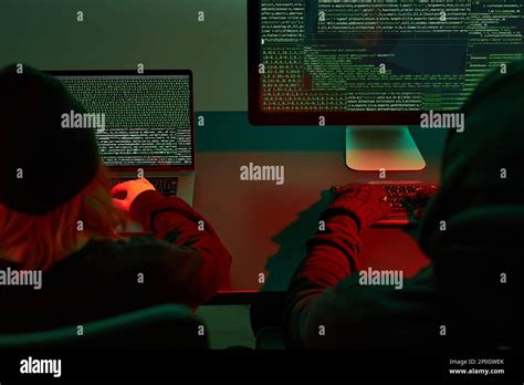 Anonymous people using computer and programming to break code. Cyber ...