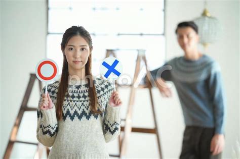 マルとバツの札を持っている女性と脚立の横に立つ男性 No 25829696｜写真素材なら「写真ac」無料（フリー）ダウンロードok