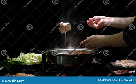 Cropped Shot Of Woman Eating Shabu Shabu In Hot Pot With Fresh Sliced